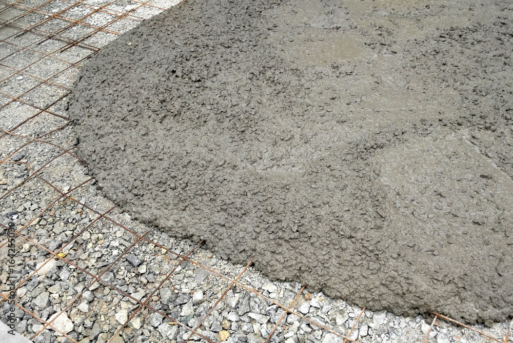 The wet concrete is poured on a steel reinforcement bar to form strong ...