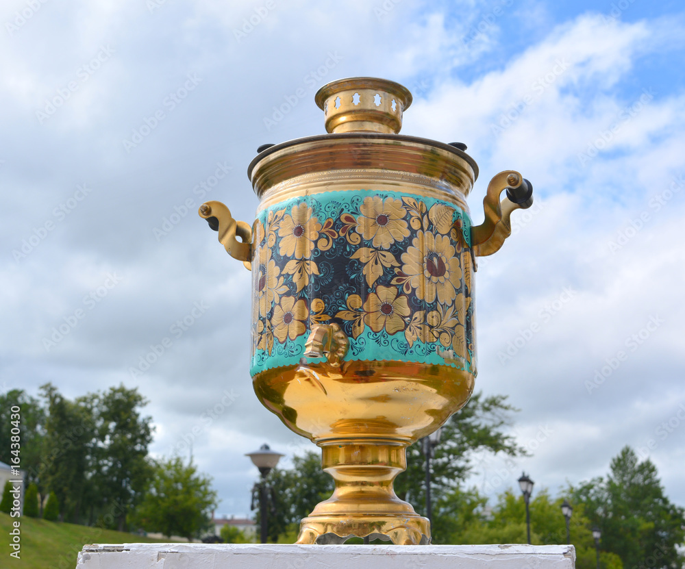 Exquisite golden samovar against the blue sky. Russian tea souvenir ...