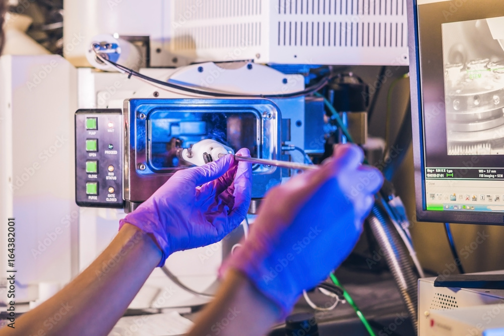 Scientist in a laboratory works with an electron microscope gateway ...