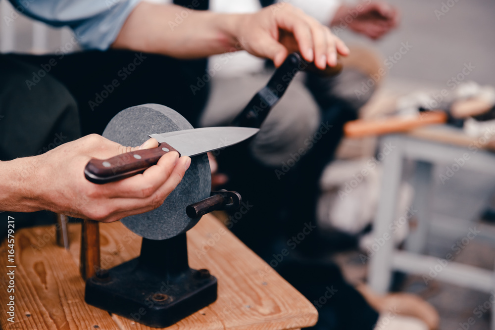 Zdjęcie Stock: master sharpens the knife by tradition on a hand ...