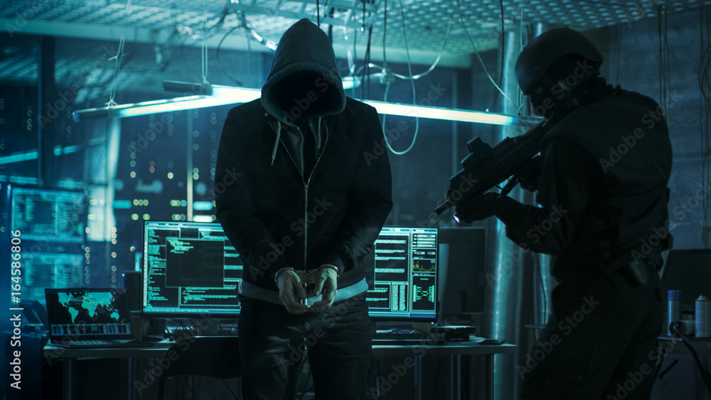 Handcuffed Masked Hacker is Standing and Guarded by Fully Armed Special ...