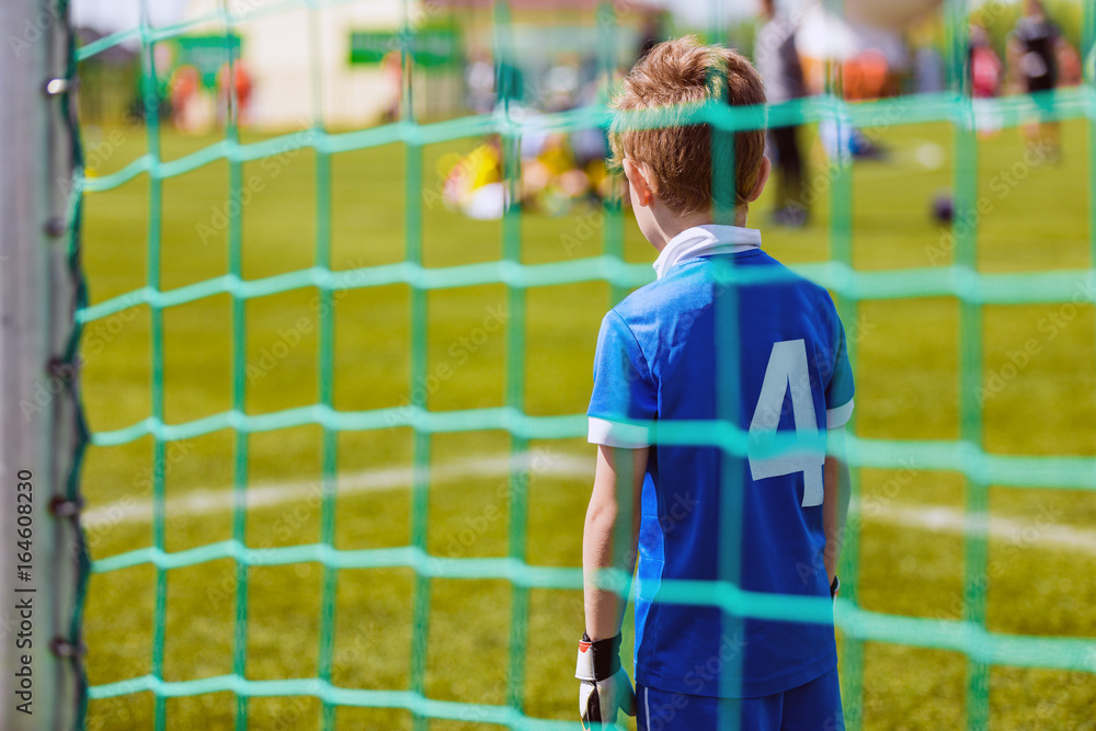 Young boy as a soccer goalkeeper during football match ready to save ...