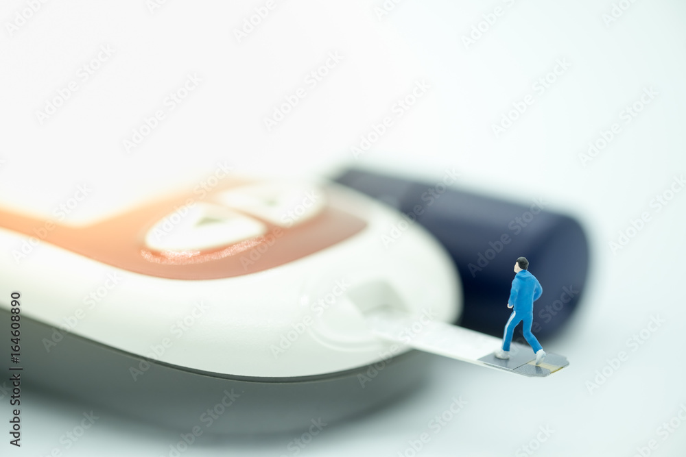 Close up of runner miniature figure running on blood sugar test strip ...