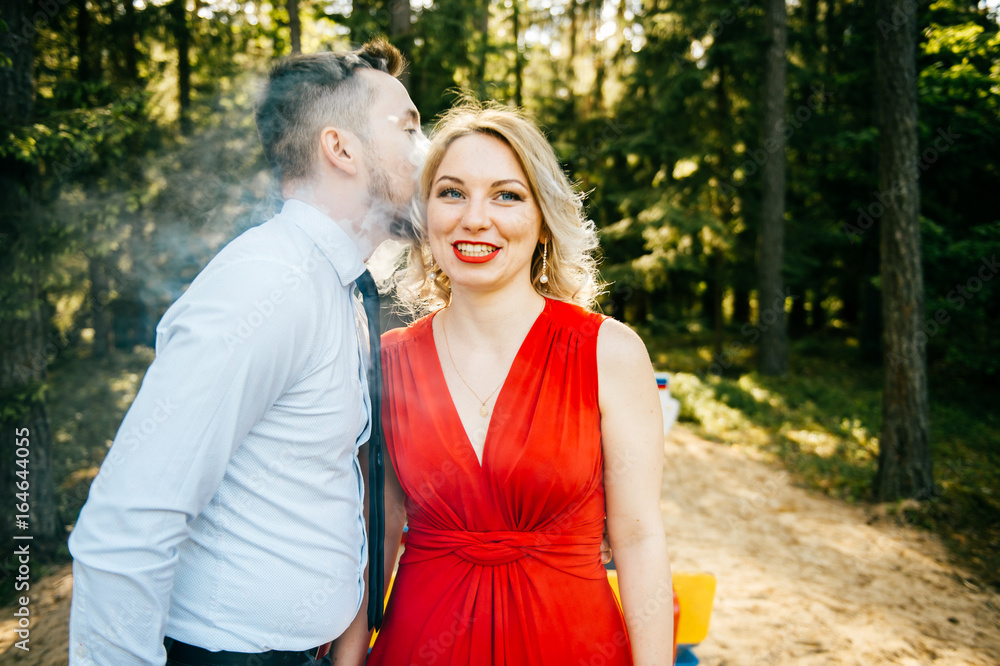 Smoking man in business clothes kissing young blonde girl with red lips ...