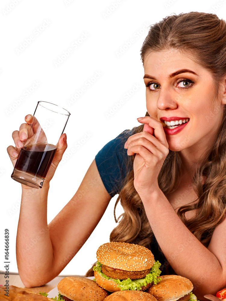 Woman eating french fries and hamburger. Student consume fast food on ...