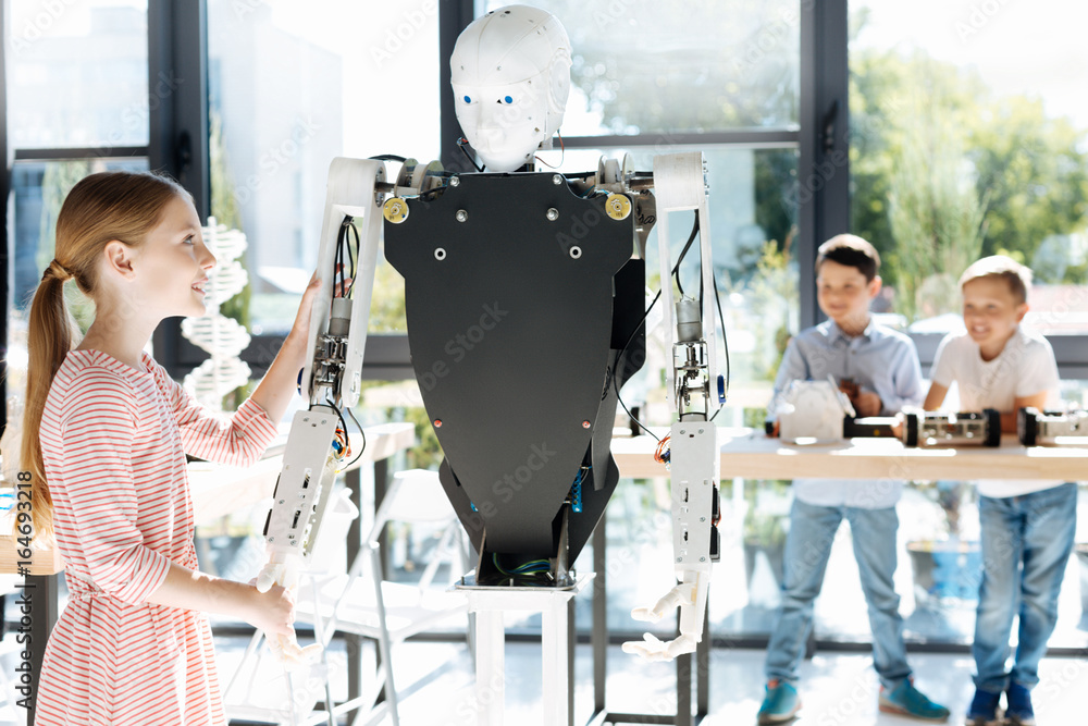 Pre-teen girl checking the suppleness of robotic hand Stock Photo ...