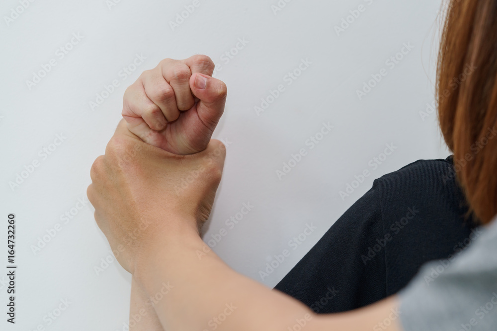 Man hand oppressing or pressing woman wrist on the wall - woman ...
