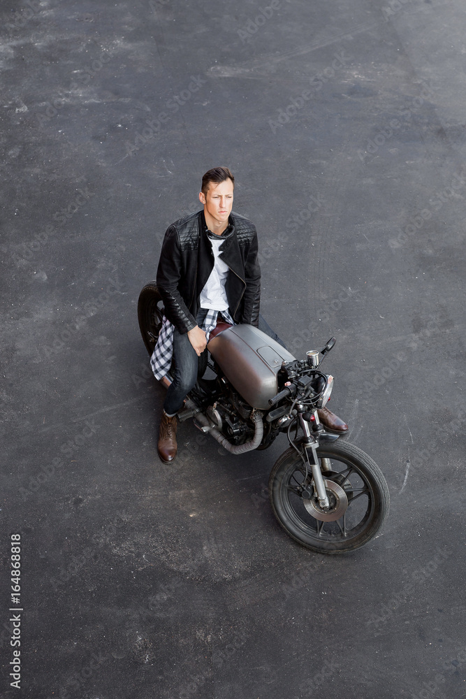Top view of a handsome rider man in black biker jacket, checkered shirt ...