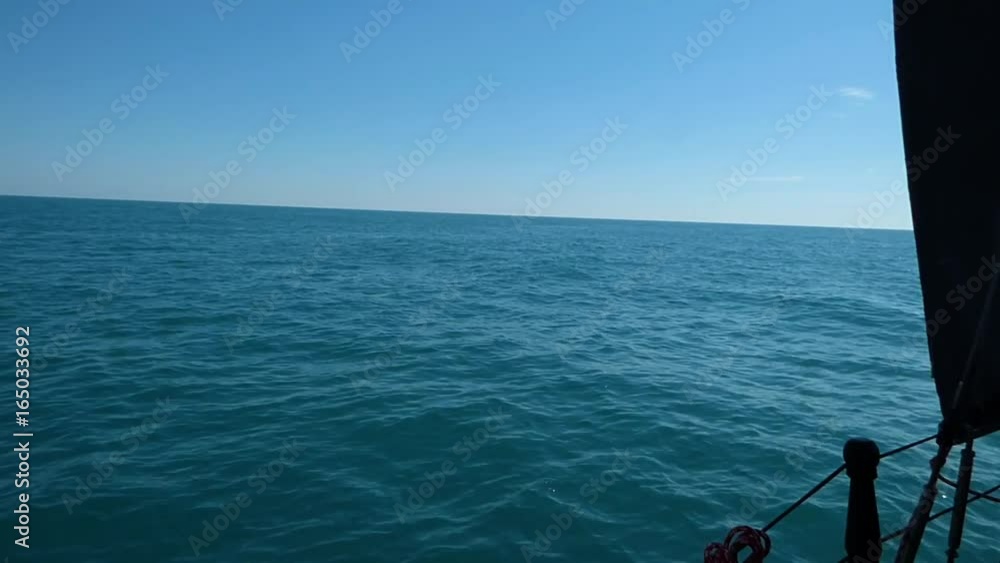 Open sea - view from pirate ship side. Boat with black sail moving fast ...