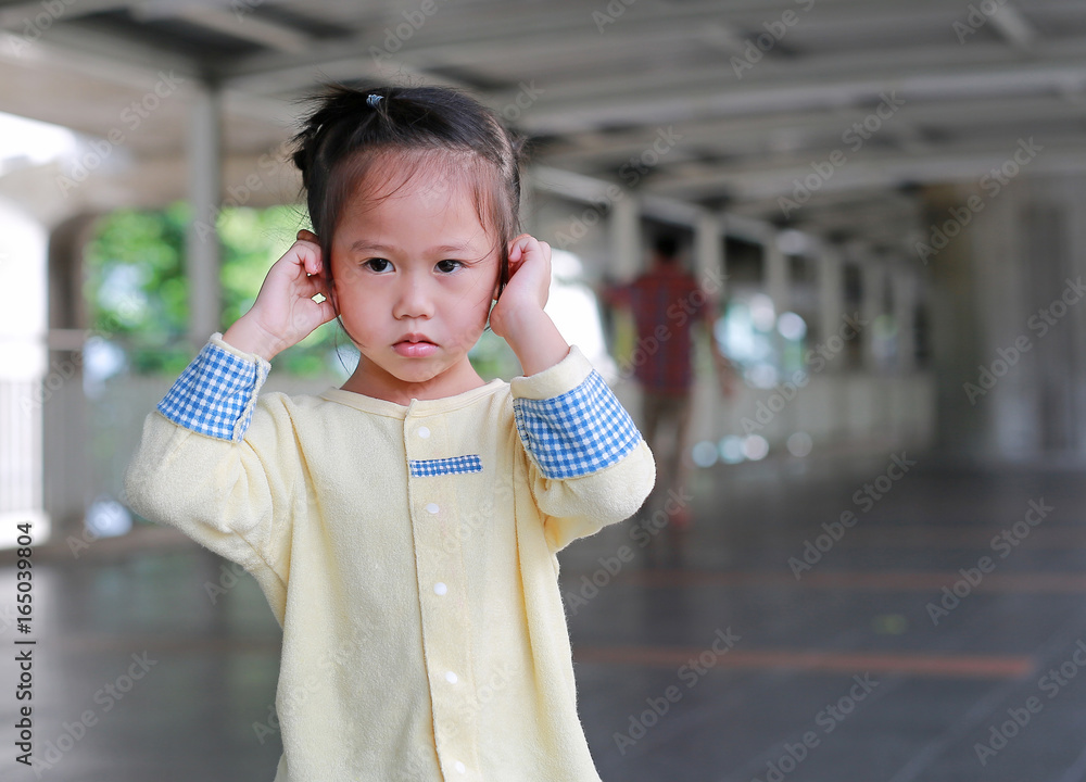 Cute little child girl shutting down her ears, holding her hands covers ...