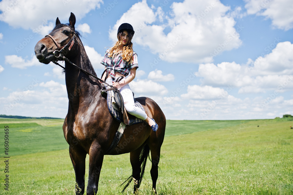 Young pretty girl riding a horse on a field at sunny day. Stock Photo ...