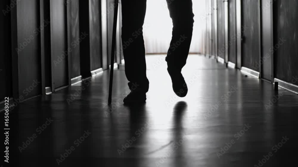 PAN with low-section of silhouette of legs of male patient with walking ...