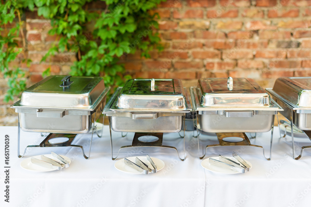 Buffet heated trays standing in line ready for service. Outdoors buffet ...