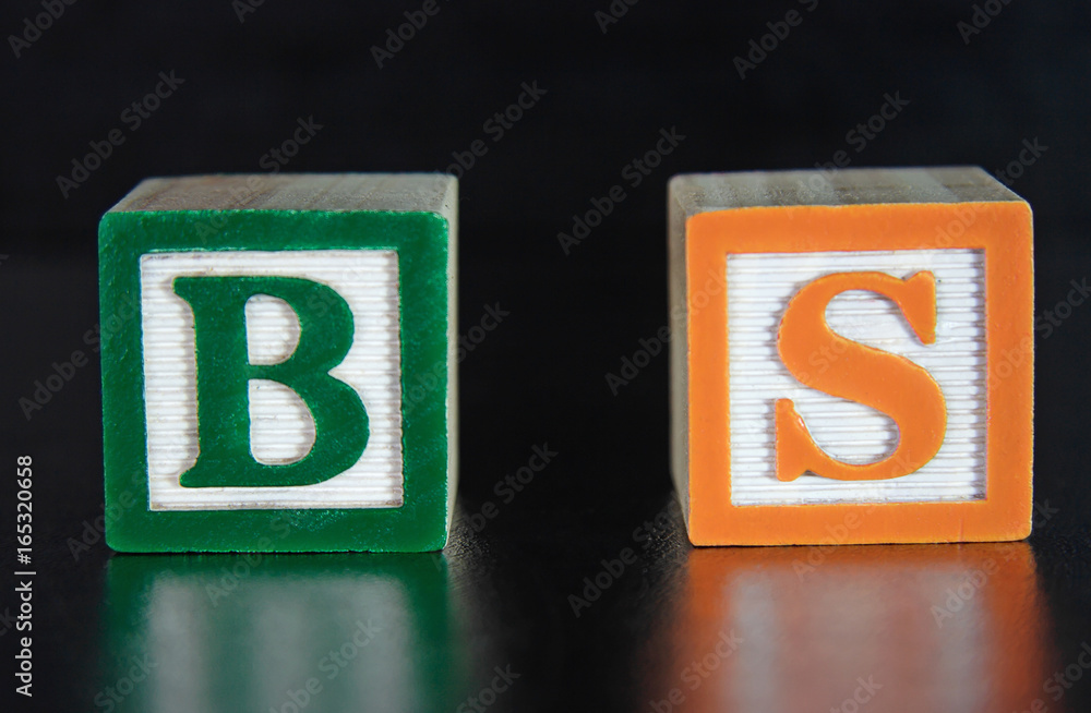 The concept BS spelled with toy alphabet blocks on a black background ...