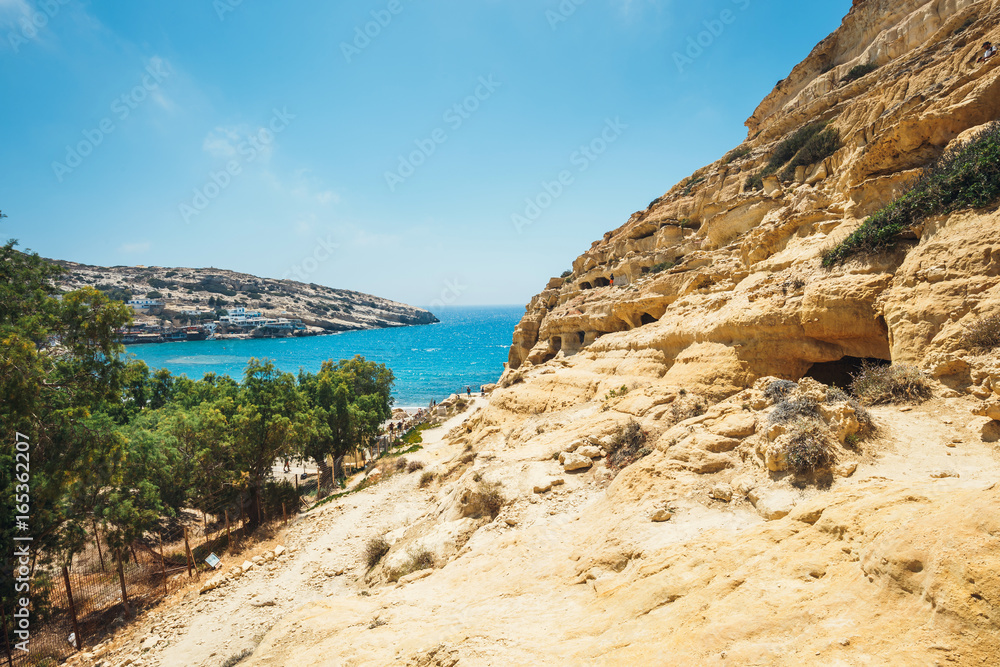 Matala beach. Caves on the rocks were used as a roman cemetery and at ...