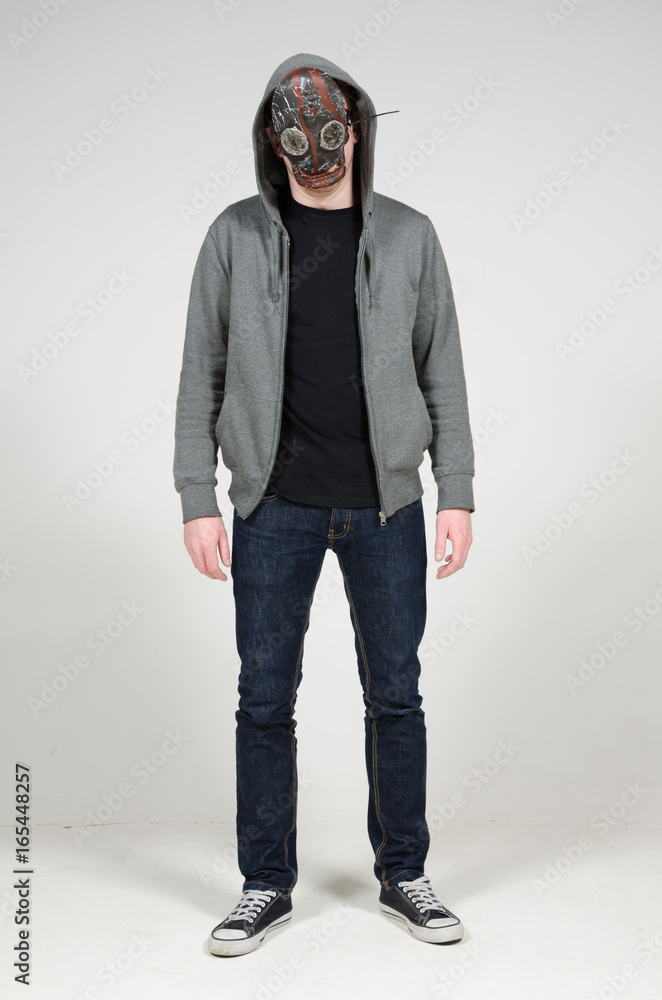 A man wearing a scary mask, photographed against a white infinity curve ...