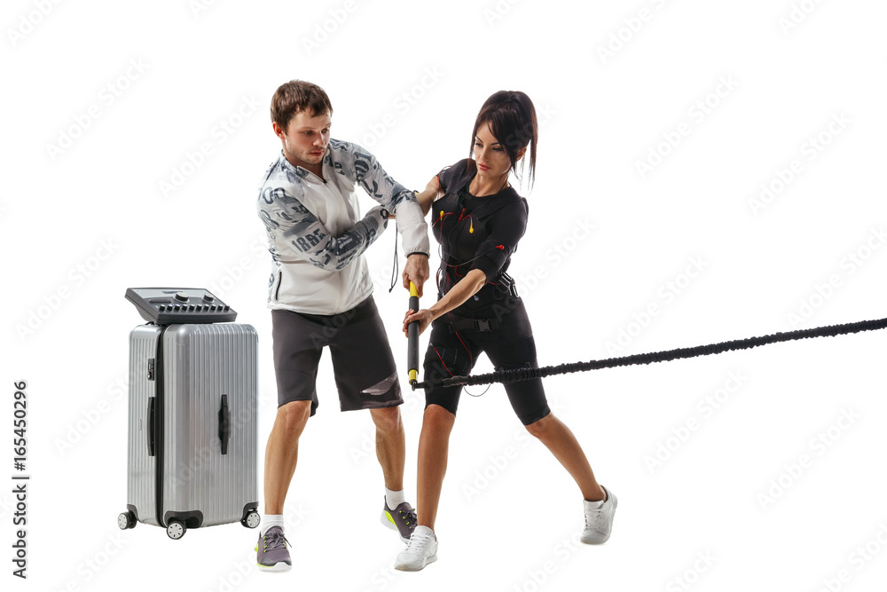 EMS fitness woman in full electrical muscular stimulation suit doing ...