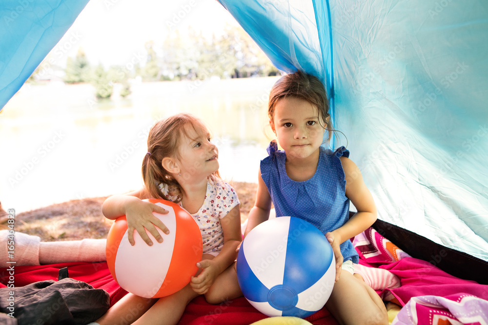 Beautiful little girls in tent camping by the lake. foto de Stock ...