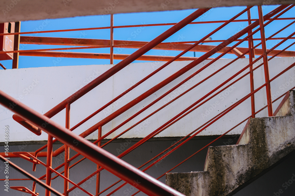 Light staircase with red handrails and concrete walls abstract ...