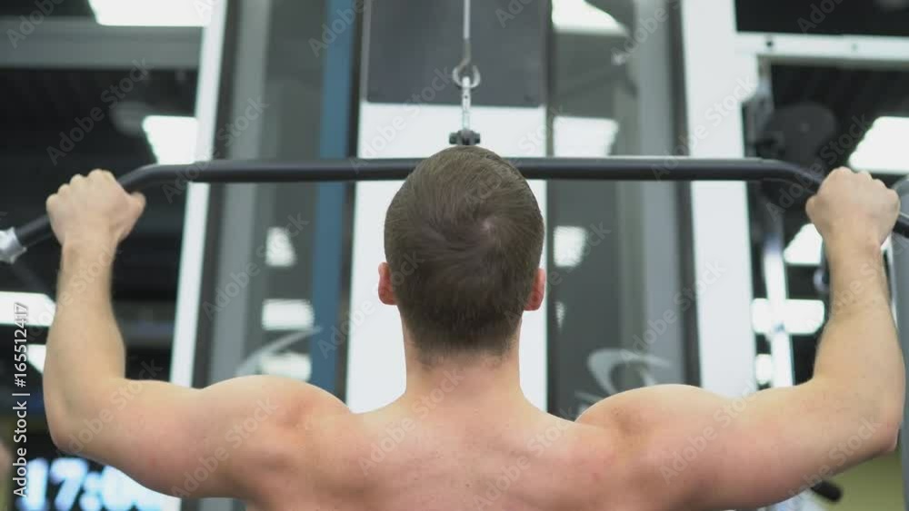 The athlete does exercises for the muscles of the back. Muscular back ...