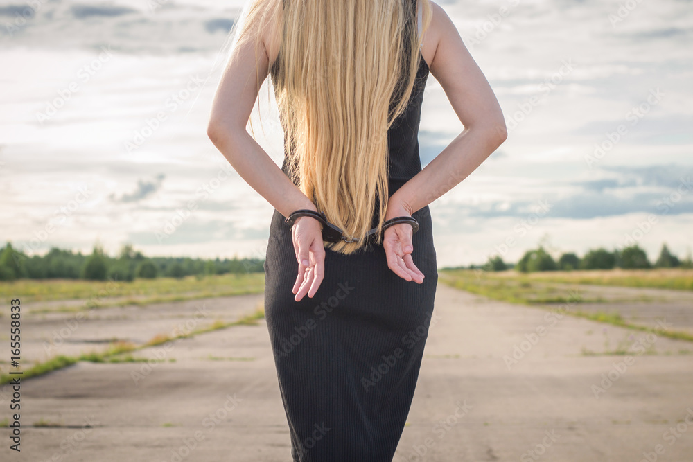 A beautiful married model girl with long hair with handcuffs on her ...