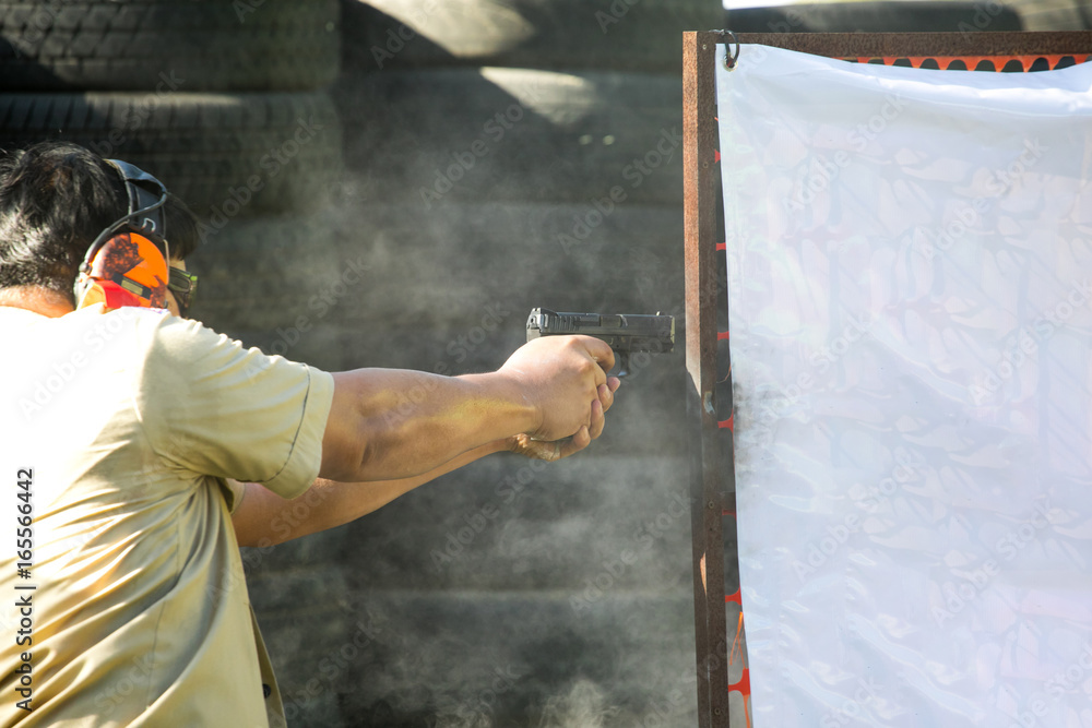 Shooting with a pistol. Man Firing pistol in shooting range. Stock ...
