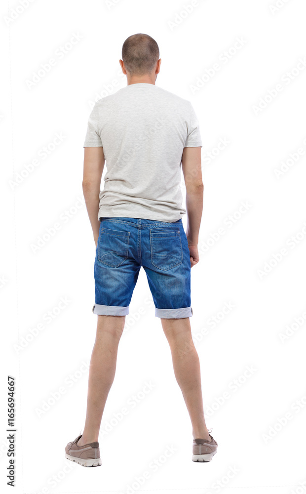 Back view of young man in shorts looking. Rear view people collection ...
