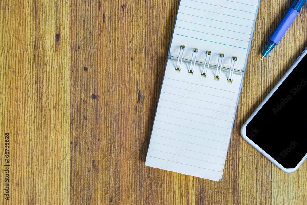 Notepad, pen, and smart phone on wooden table. Using wallpaper or ...