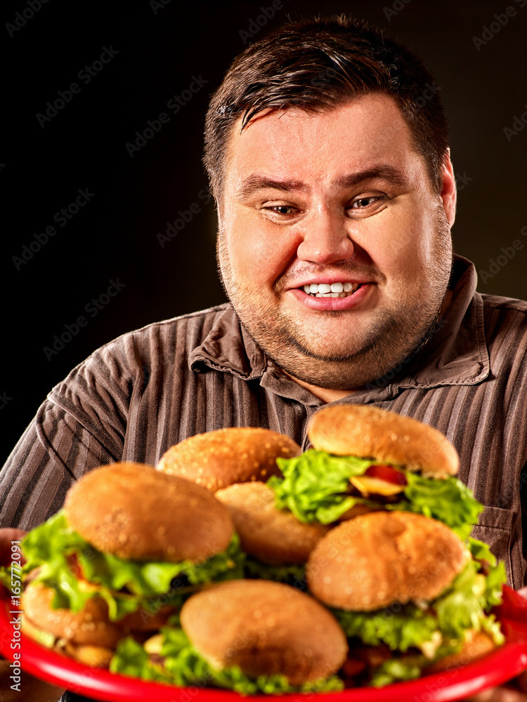 Fat man eating fast food hamberger and carries treat for friends on ...