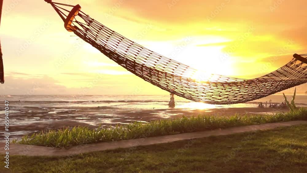 SLOW MOTION CLOSE UP LENS FLARE: Empty hammock swinging in light summer ...