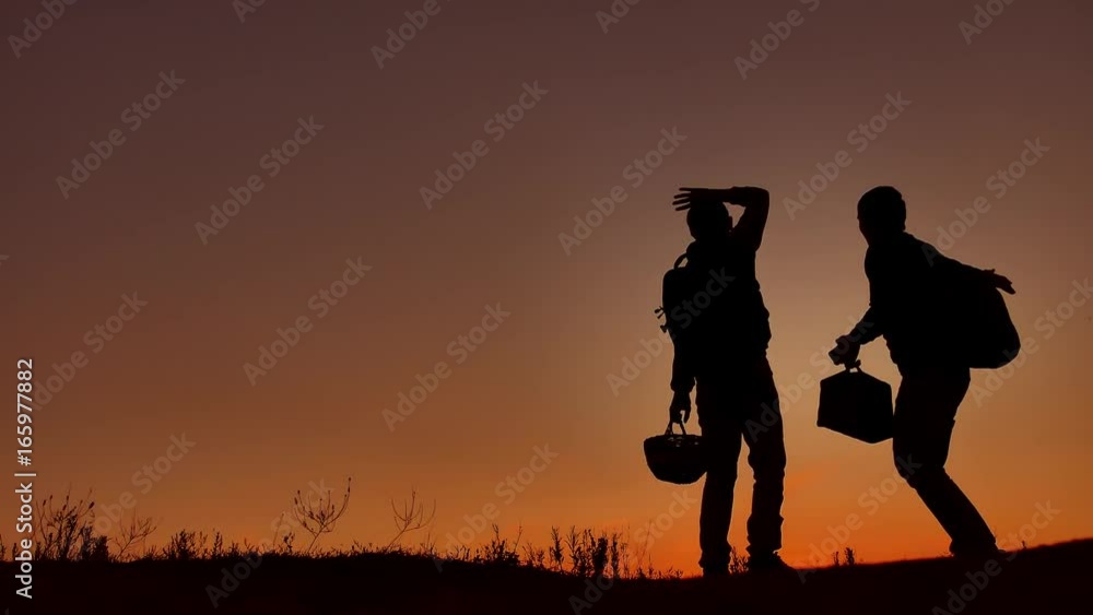 Two people tourists call for help silhouettes of the sunrise. Danger ...