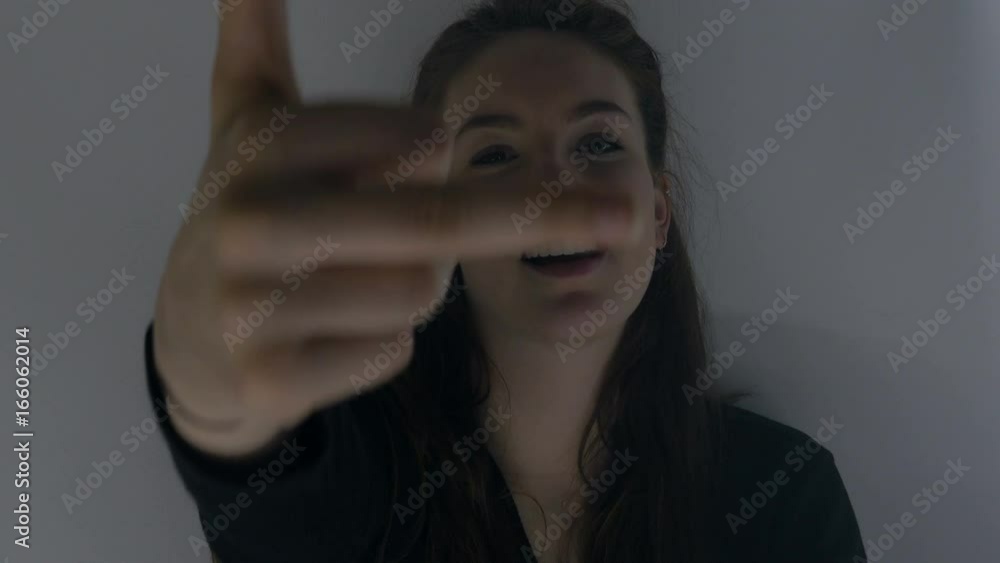 A young female is giving the middle finger hand gesture while standing ...