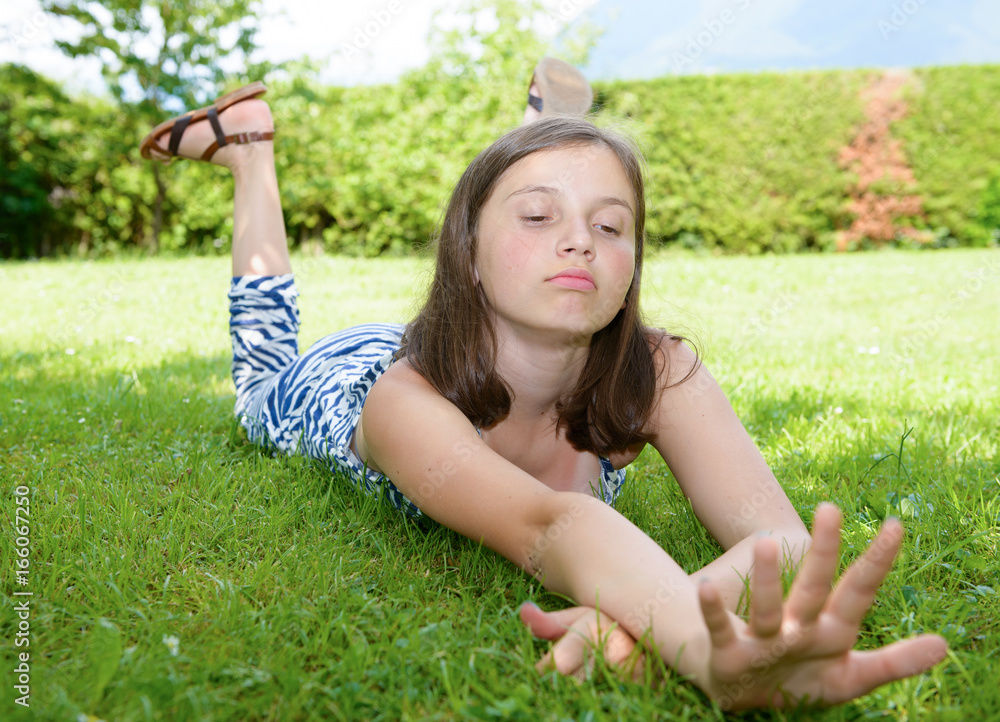 pretty pre teen girl lying in grass Stock Photo | Adobe Stock