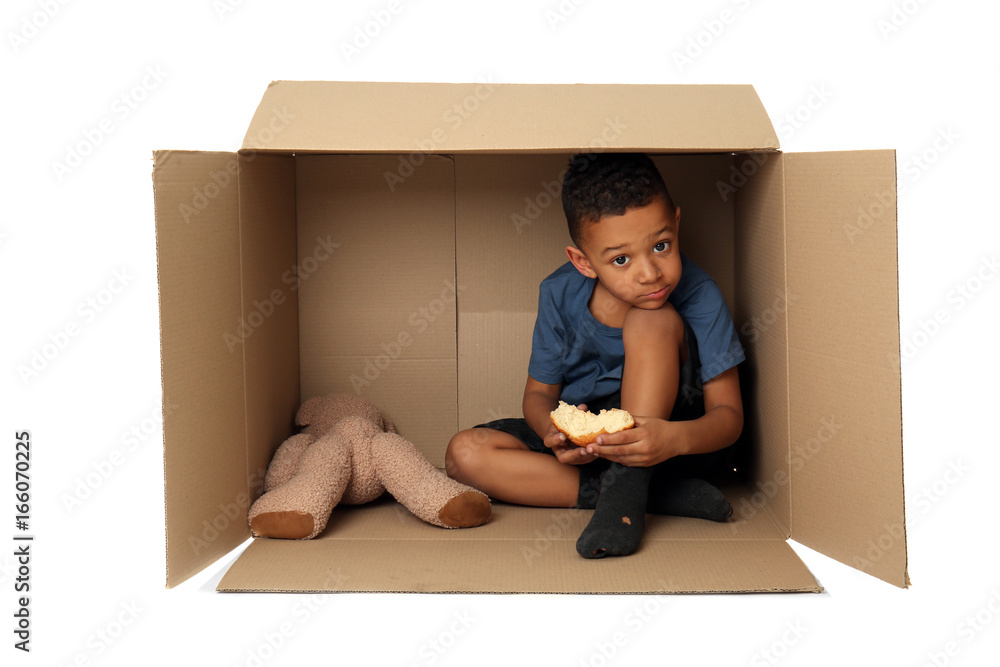 Cute little boy living in box on white background. Poverty concept ...