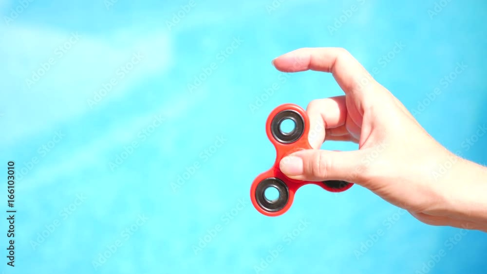 Red hand spinner or spinner, rotating on the person's arm. A woman ...