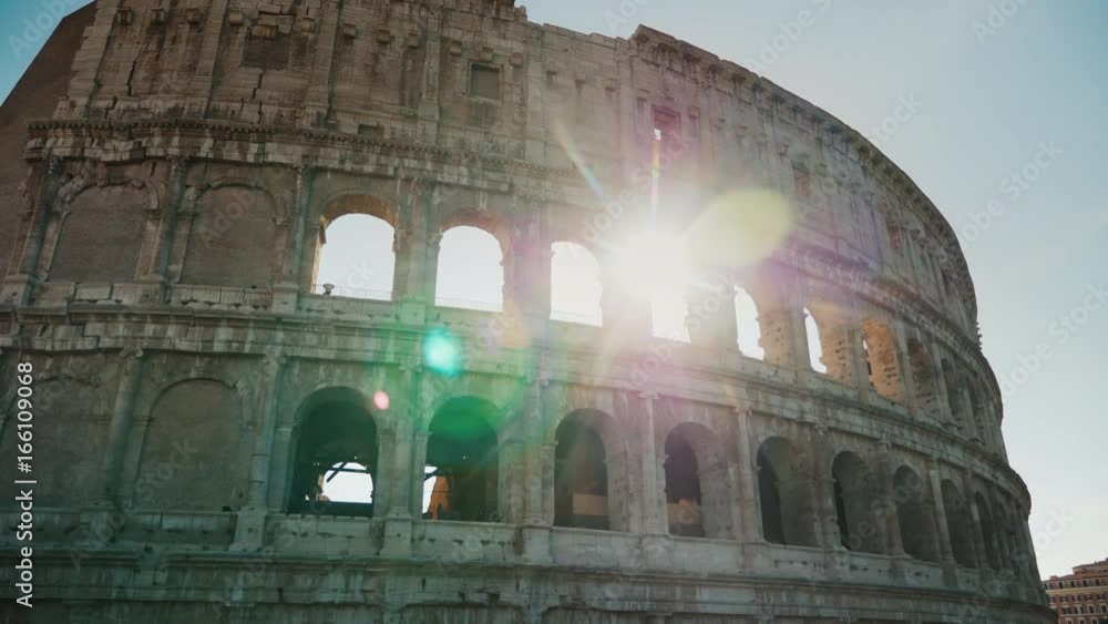 The sun shines beautifully through the arches of the Colosseum in Rome ...