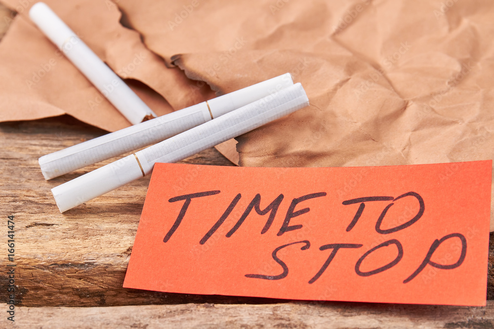 Time to stop smoking cigarettes. Burnt old paper, message, cigarettes ...