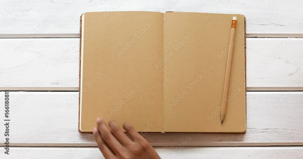 male hand open diary paper 6 brown page then close on the white wooden ...