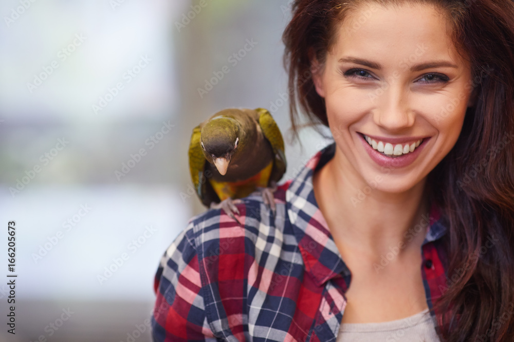 parrot sitting on a girls hand and kissing her . Stock Photo | Adobe Stock