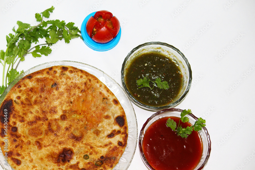 Indian food stuffed potato paratha with tomato and coriander sauce ...