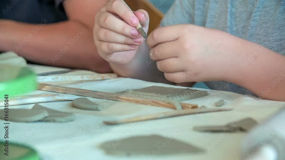 Young school children are using different tools and brushes when they ...
