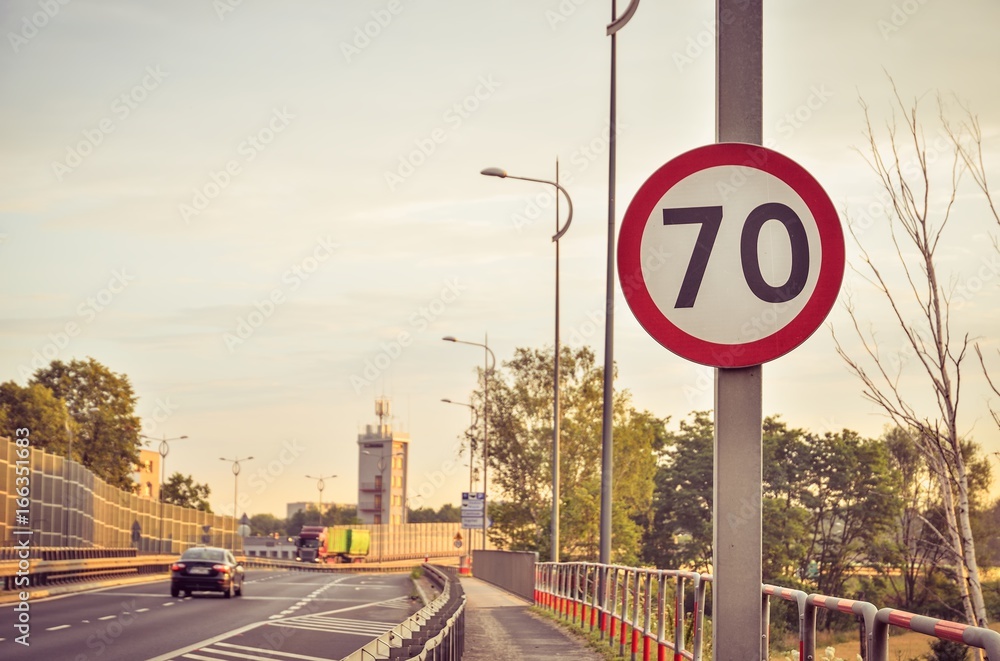 Prohibition road sign. Speed limit to 70 km/h in shallow depth of field ...