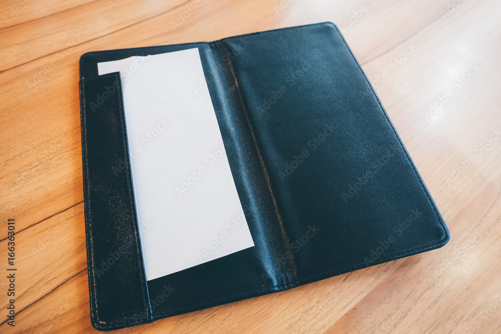 Blank empty white paper in black leather restaurant payment billing ...