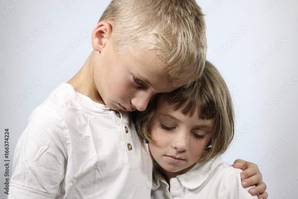 Portrait of grieving young children in an embrace Stock Photo | Adobe Stock