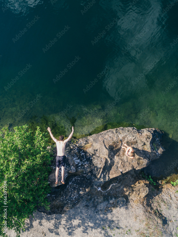 Overhead drone image of teenagers jumping off a rock Stock Photo ...