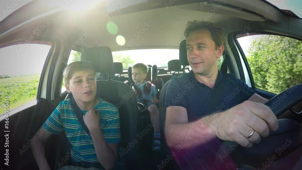 Children boys brothers riding in the car with father male in vehicle ...