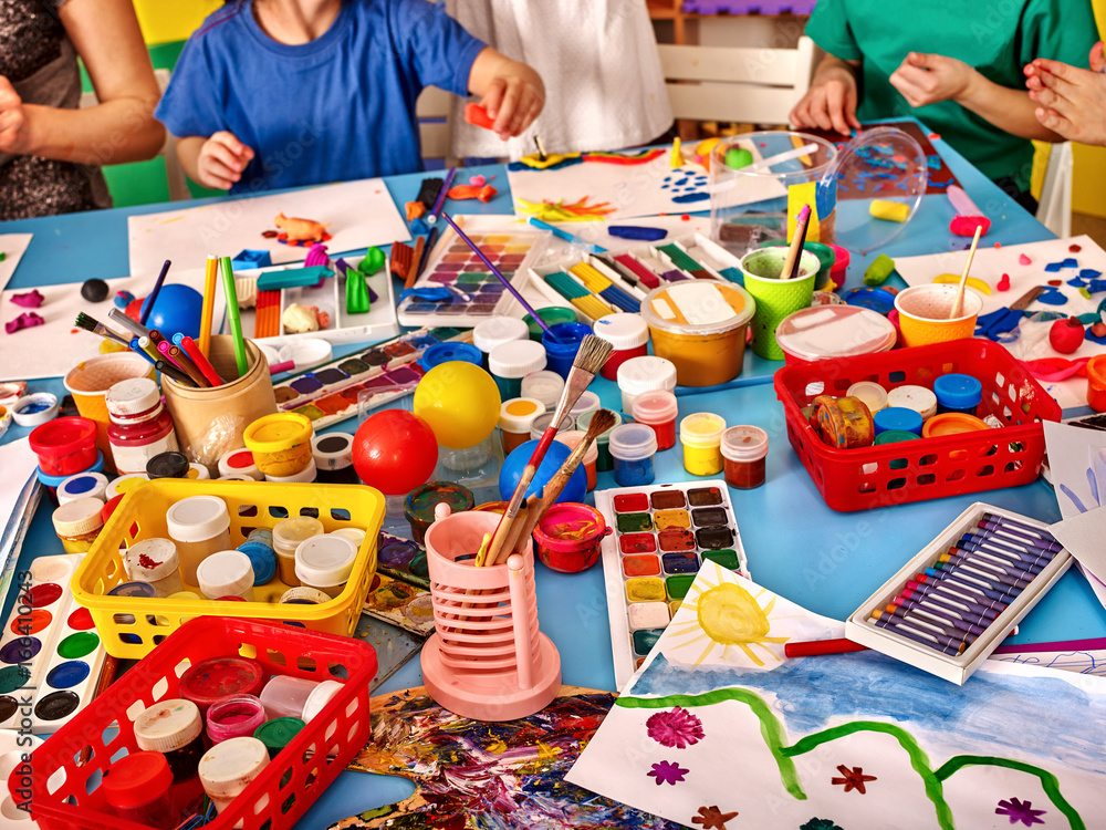 Kindergarten tables with painting brush and teacher in interior ...