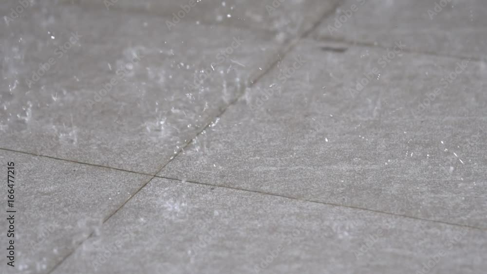 Vidéo Stock The slow movement of falling rain hits the gray tile floor ...