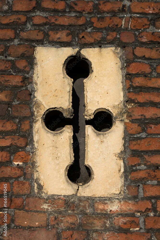 Detail of cross-shaped window slit in Tudor architecture exterior wall ...