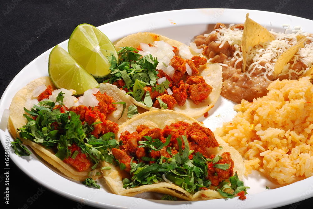 Three sof tacos plate, cilantro, rice and beans, cheese, lemon and chip ...